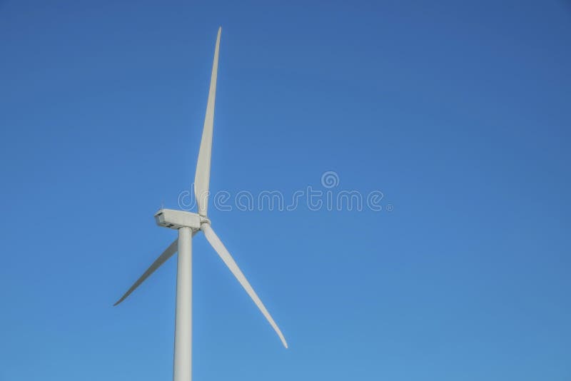 Close Up View of a White Windmill with Three Sharp Blades Against Blue ...