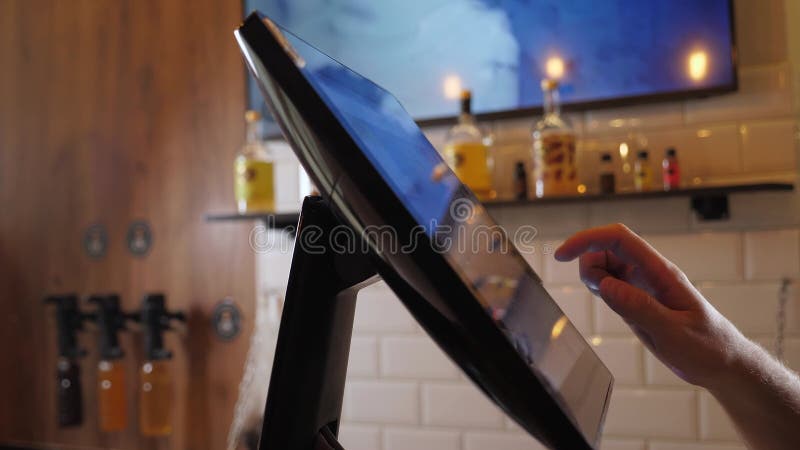A Close-up of a Waiter or Bartender Working at a Computer in a Cafe ...
