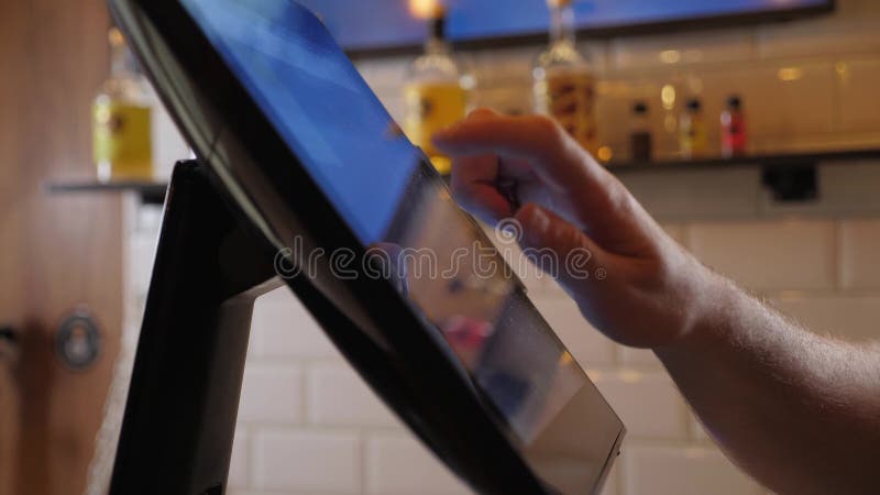 A Close-up of a Waiter or Bartender Working at a Computer in a Cafe ...