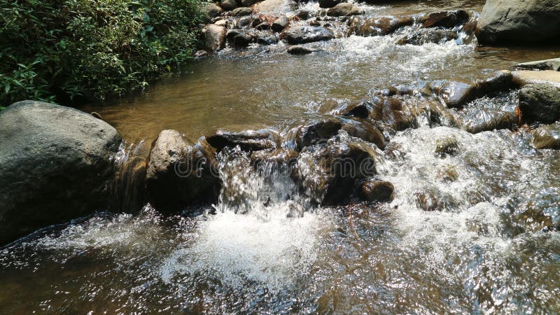 Close-up Water Flows through a River with Different Sized Stones in it ...