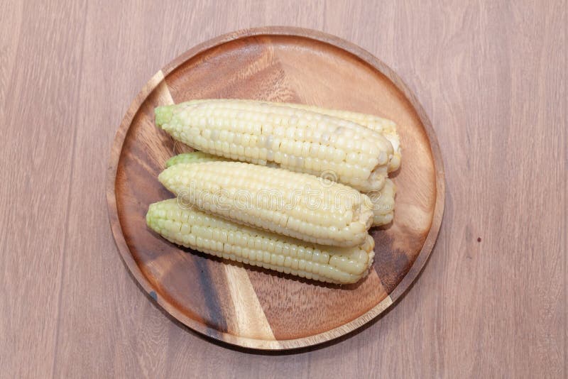 Waxy corn in wooden plate stock photo. Image of food - 128944760