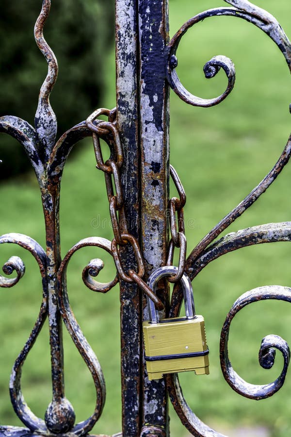 Close-Up of a Weathered Wrought Iron Gate with Rusty Chain and New ...