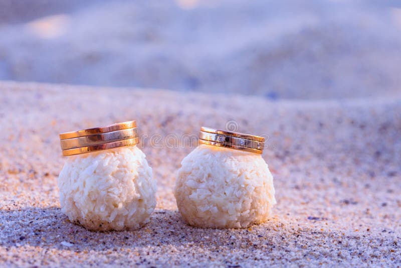 Close Up of Wedding Rings with Candies on the Sand. Wedding Concept ...