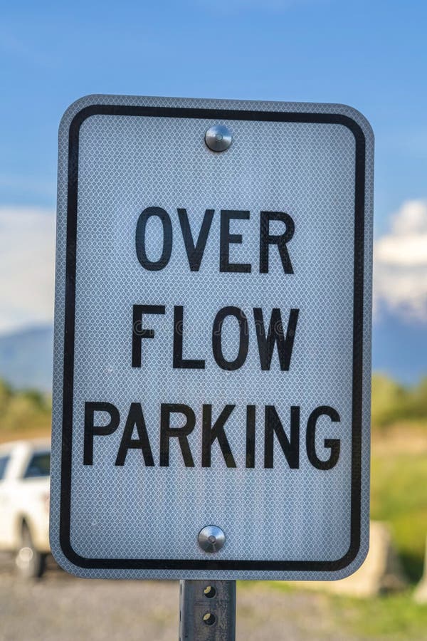 Close Up of a White and Black Rectangular Sign that Reads Over Flow ...