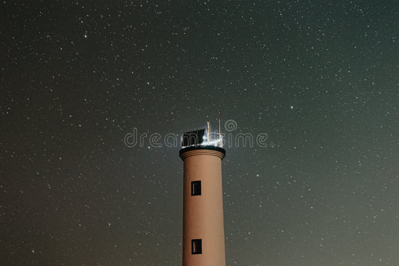 A Close Up of a White Lighthouse with a Sky Filled of Stars Stock Photo ...