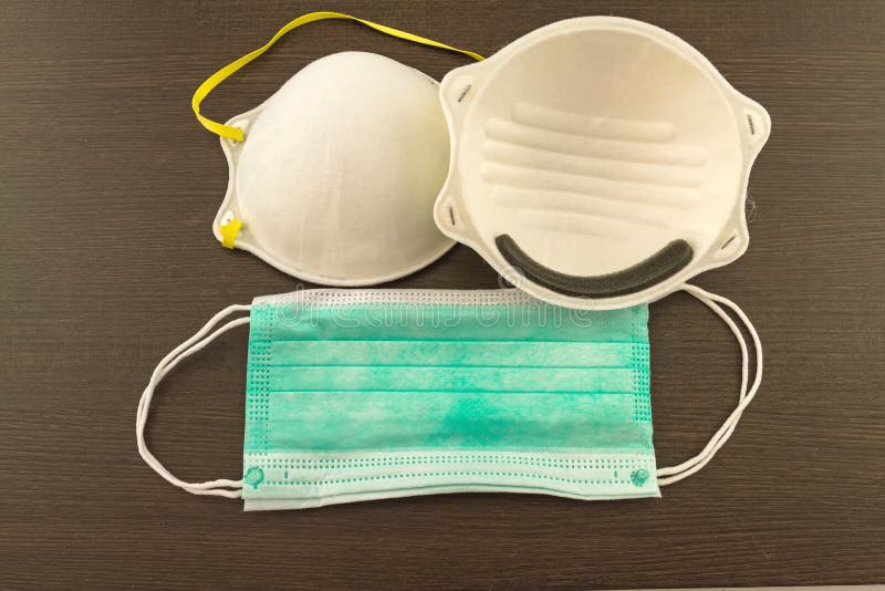 Close Up of White Mask and Blue Surgical Mask Stack on Black Wooden ...