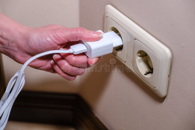 Close-up Woman Hand Puts Plug in the Electricity Socket. Female Hand ...