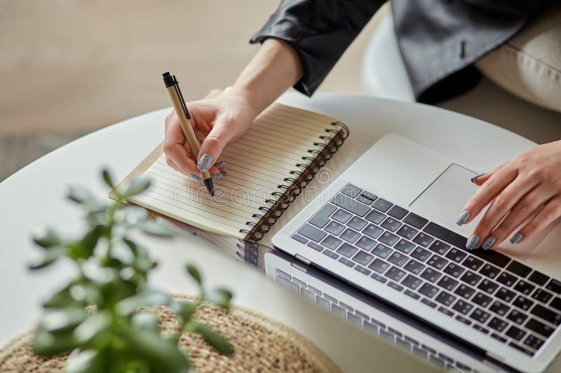 Close Up Woman Hand Using Laptop and Making Notes in Notebook Sitting ...