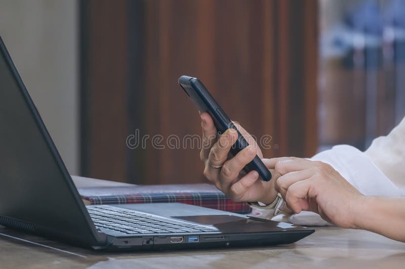 Close Up Woman Hand Using Smartphone and Laptop Computer on Office Desk ...