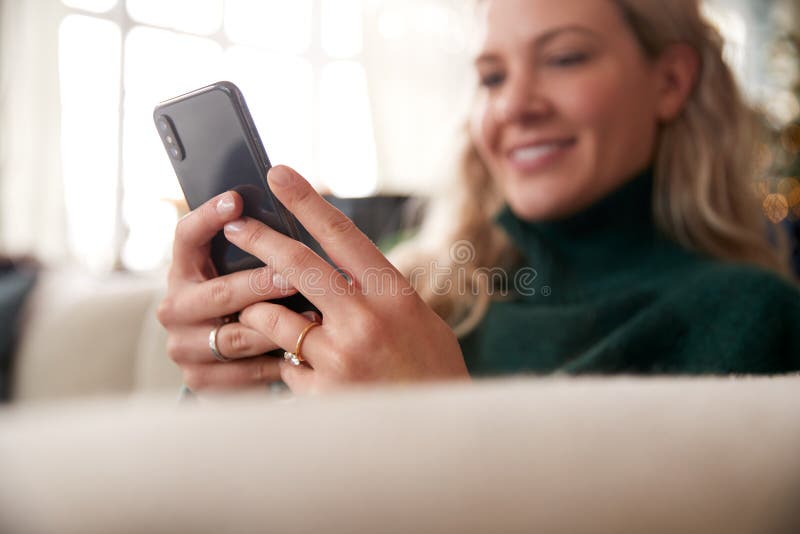 Close Up of Woman Relaxing on Sofa at Home Using Mobile Phone Stock ...