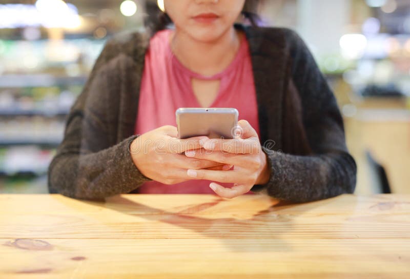 Close-up Woman Using Smartphone on Table at Department Store Stock ...