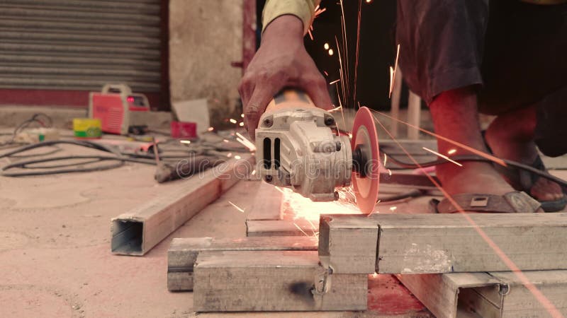 Close Up of a Workers Hand Using an Angle Grinder on Metal with Sparks ...