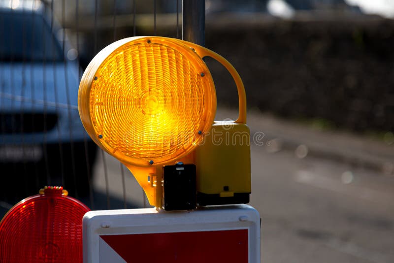 Close-up of Yellow and Red Warning Lights with Street Barriers at a ...