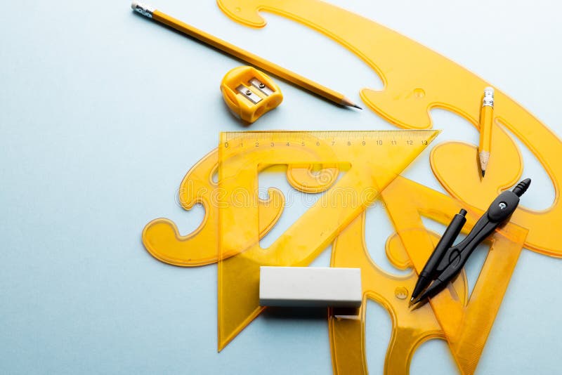 Close Up of Yellow Rulers, Compass and Sharpener on Blue Background ...