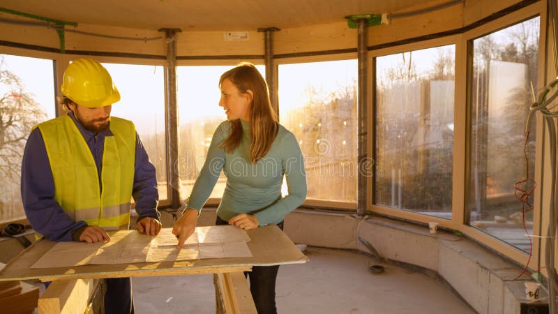 CLOSE UP Woman Points at Plans while Talking about Construction Site ...