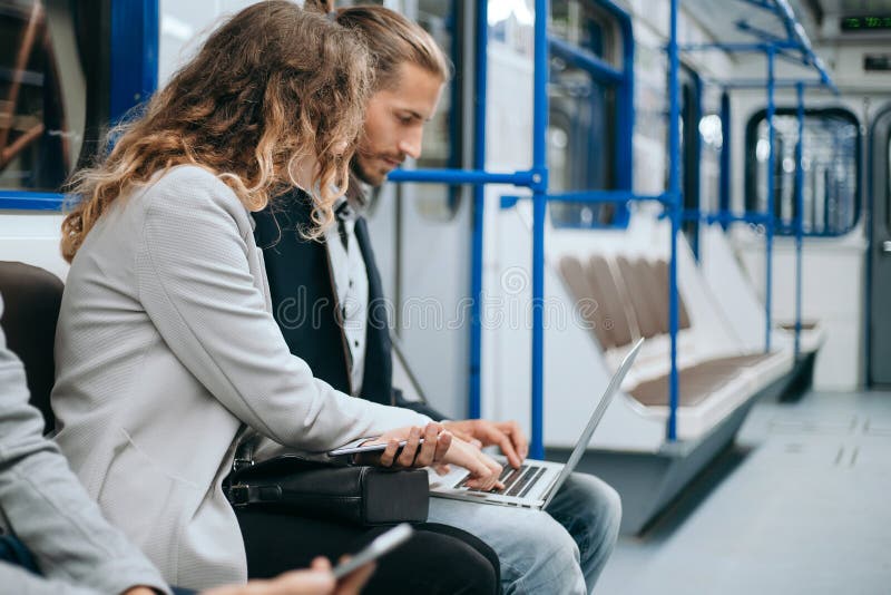 Young Couple Using Laptop Sitting in Subway Car. Stock Image - Image of ...