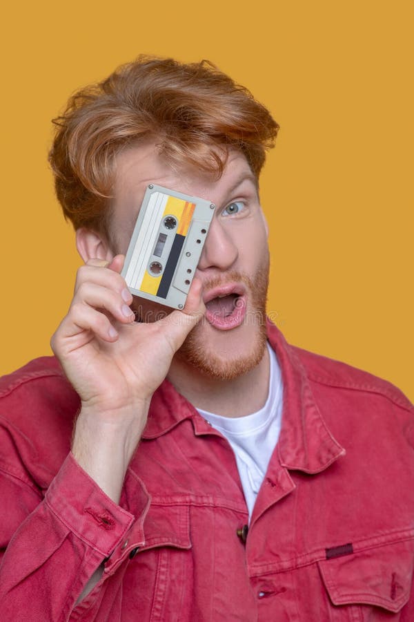 Close Up of Young Ginger Man in Red Jacket Holding a Cassette Stock ...
