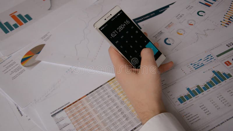 The Close Up of Young Guy Hands Using Calculator and Documents Charts ...