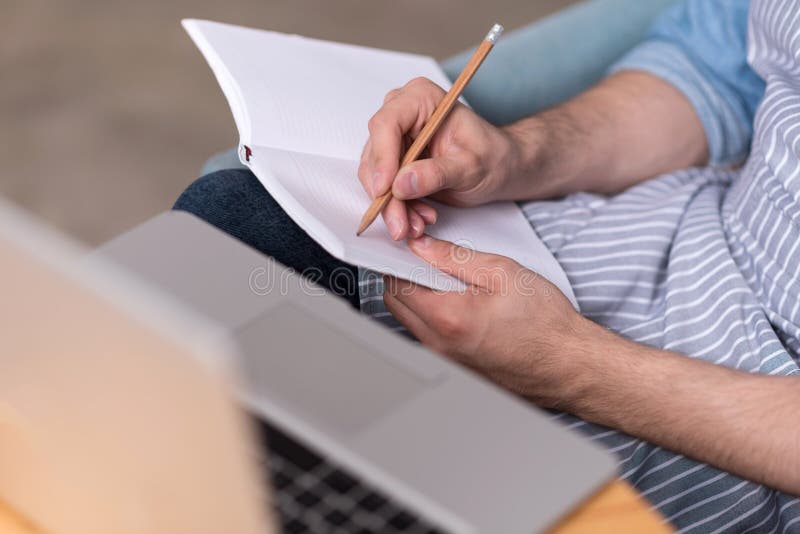 Close Up of Young Man Making Notes by the Laptop. Stock Photo - Image ...