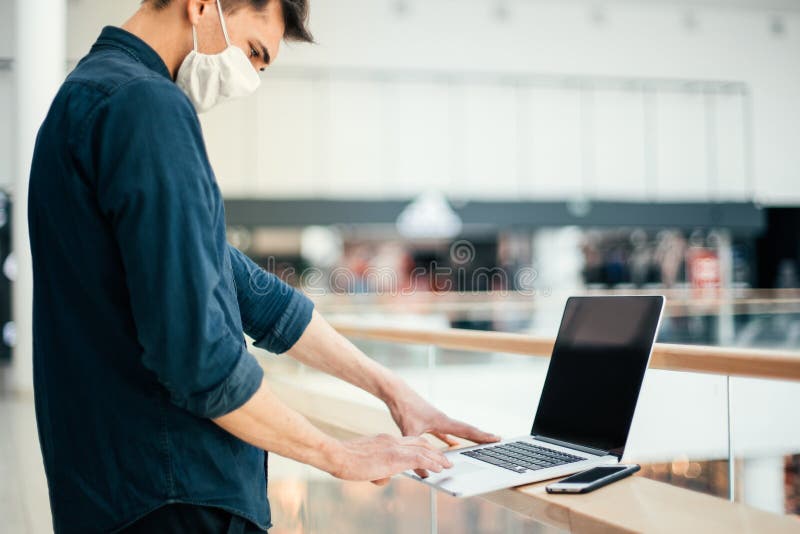 Close Up. a Young Man in a Protective Mask Using a Laptop Stock Photo ...