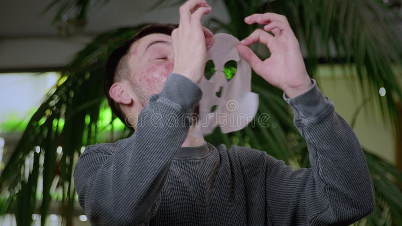 Close-up of a Young Man Removing a Fabric Mask for Skin Care ...