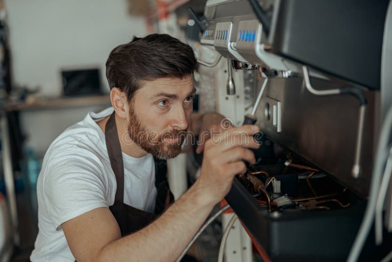 Close Up of Young Man Repairing Coffee Machine Using Screwdriver in a ...