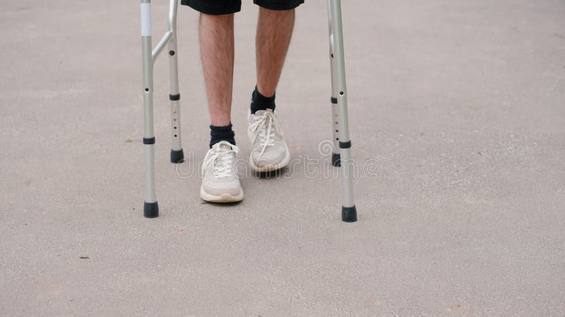 Close-up of a Young Man S Legs Using a Walker on a Path in a Green Park ...
