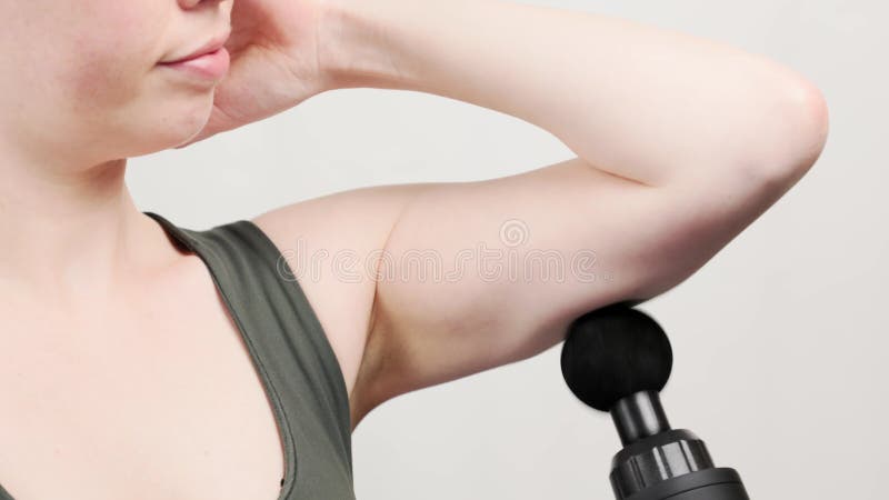 Close Up Of Young Woman Gives Herself Massage On Triceps With