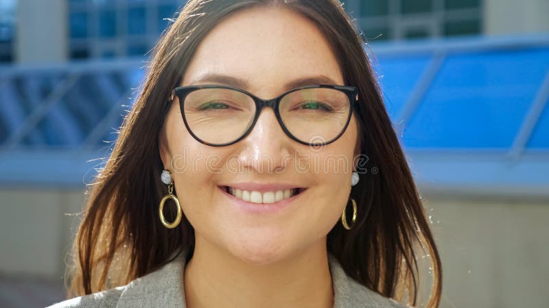 Close-up of a Young Woman Wearing Glasses Smiling at the Camera Stock ... Close-up of a Young Woman Wearing Glasses Smiling at the Camera Stock ...