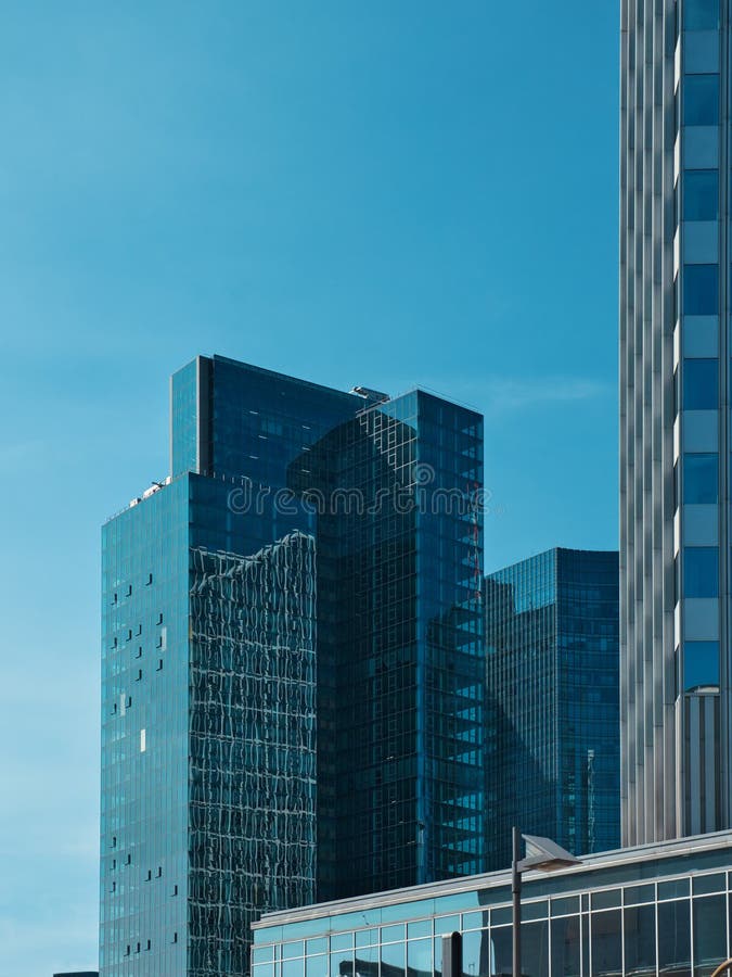 A Close-ups of a Skyscraper with a Glass Front Against a Clear Blue Sky ...