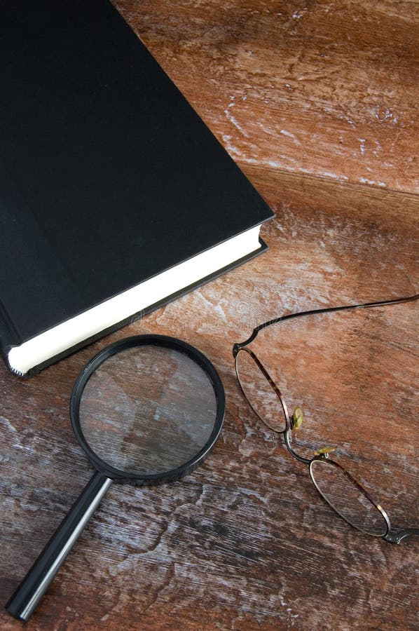 Close View of Reading Glasses and Magnifier on Large Black Book Stock ...