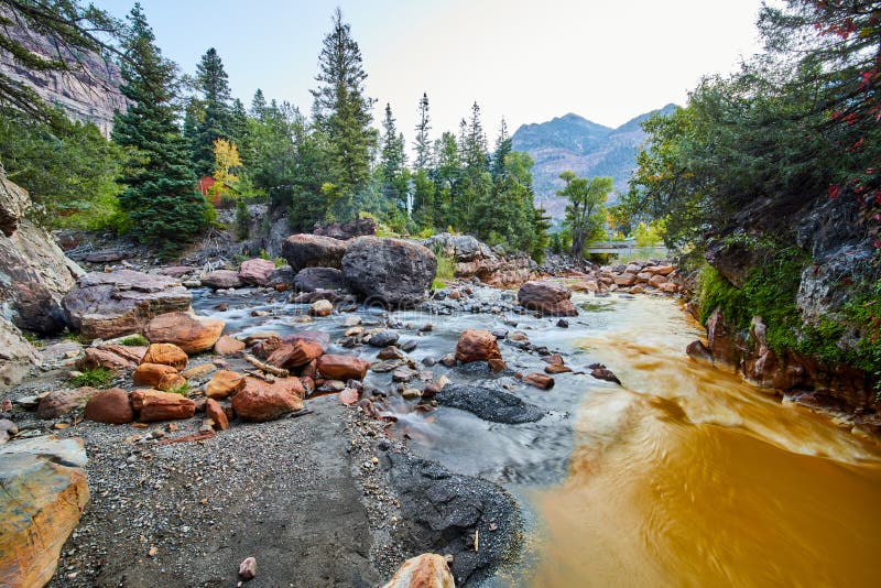 Close View of Red Rocks at River Intersection with Mountains in ...