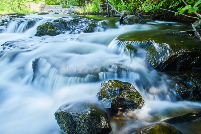 Close View of Smooth Waterfalls Over Wet Mossy Rocks with Dam Barrier ...