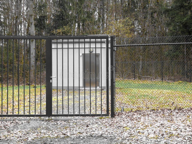 Closed Black Gate of a Facility with Trees in the Background Stock ...