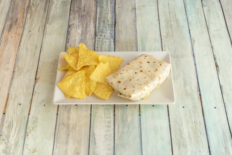 A Closed Burrito with Cheese and Corn Chips on a White Porcelain Tray ...