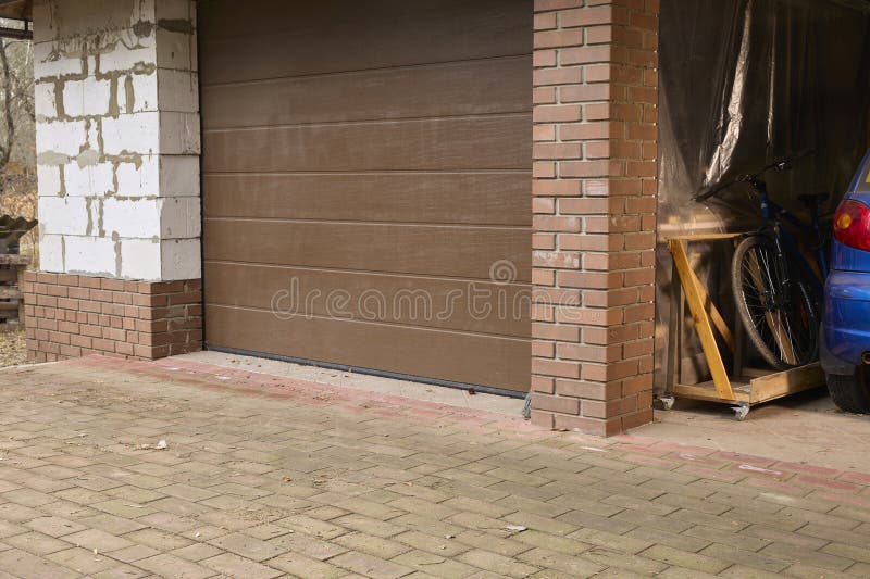 Closed Garage Door with Bicycle and Car Partially Visible Stock Photo ...