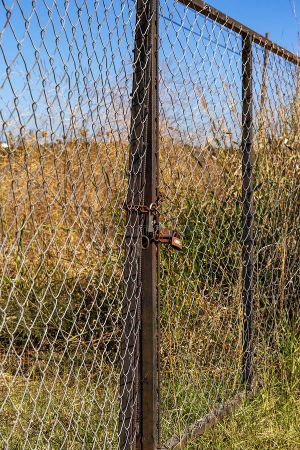 A Closed Gate in a Chain-link Fence in a Field. Close-up Stock Image ...