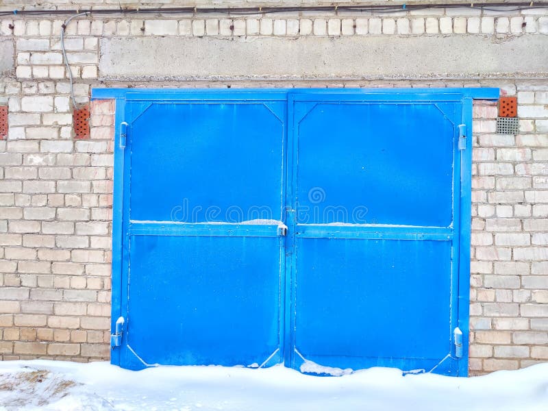Closed Iron Blue Gate on a Gray Brick Wall of Garage Outside in White ...