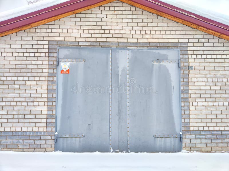 Closed Iron Gate on a Gray Brick Wall of Garage Outside in White Snow ...