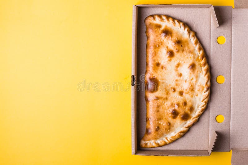 Closed Pizza Calzone in Packing Box on Yellow Background Stock Photo ...