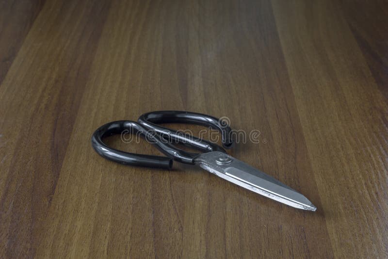Closed Scissors on a Yellow Wooden Table Surface Stock Photo - Image of ...