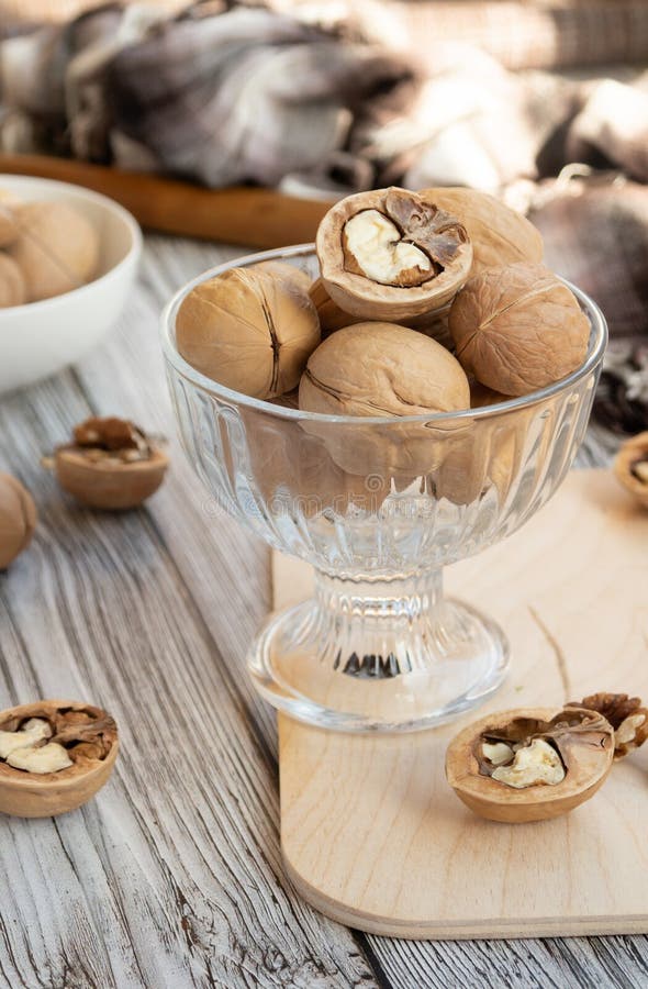 Closed and Split Walnuts in Dishes on a Light Wooden Background ...