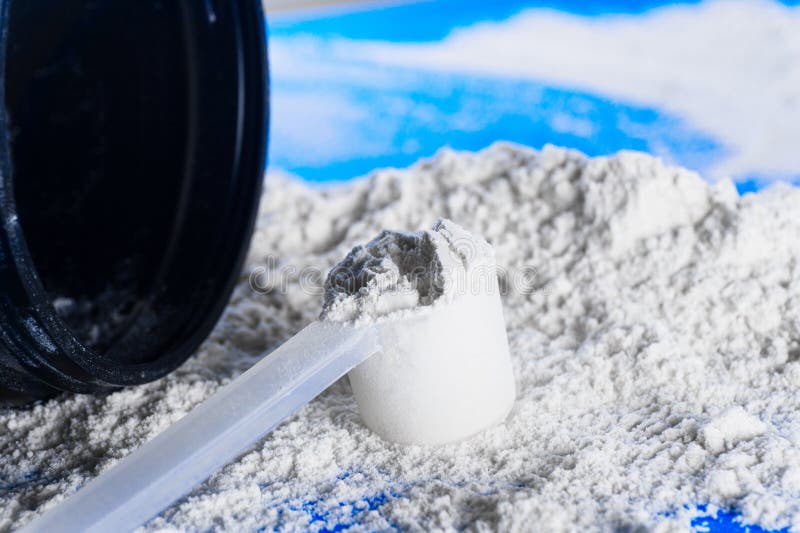 A Scoop of Creatine Powder Next To a Bottle Stock Photo - Image of ...