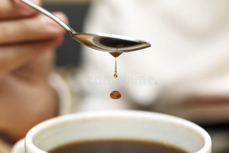 Closeup Blob of Coffee Dripping from Metal Spoon into Mug with Coffee ...