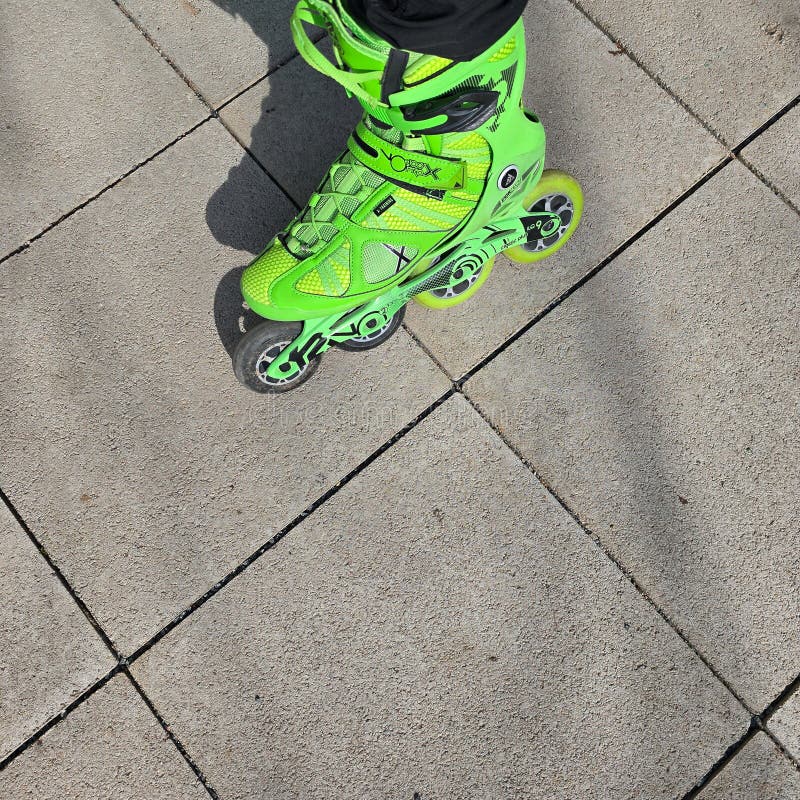 Vibrant Green Inline Skates Rolling Smoothly on a Paved Surface Under a ...