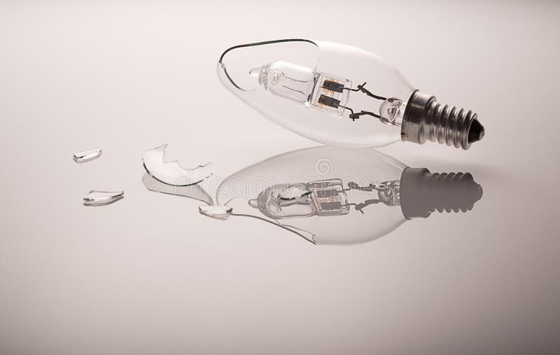 Closeup Broken Light Bulb with Reflection and Glass Pieces Next To it ...
