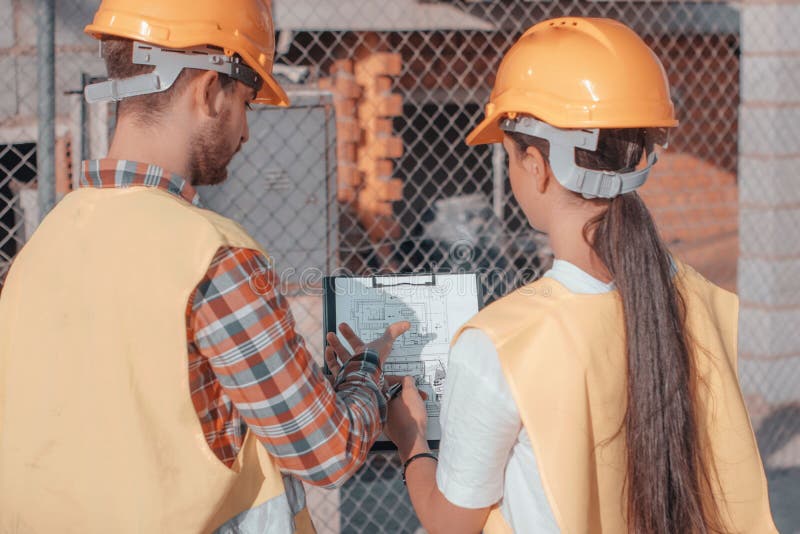 Closeup of Builders Looking at the Construction Design while Standing ...
