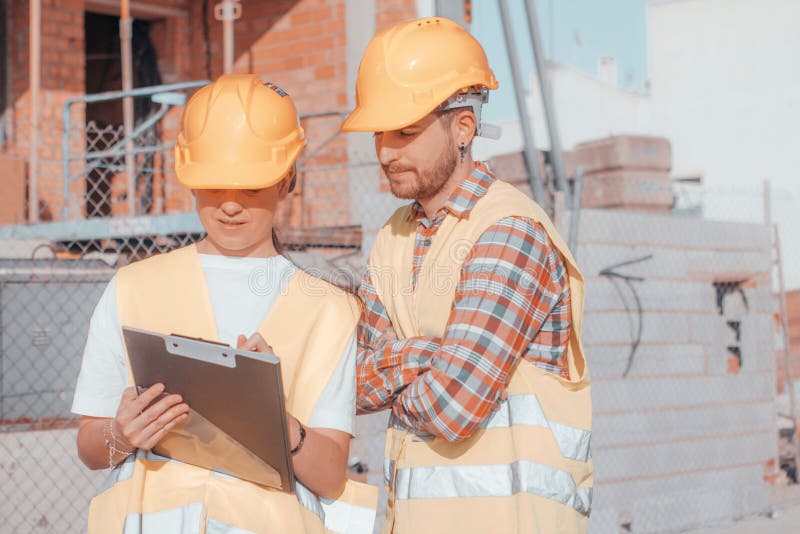Closeup of Builders Looking at the Construction Design while Standing ...