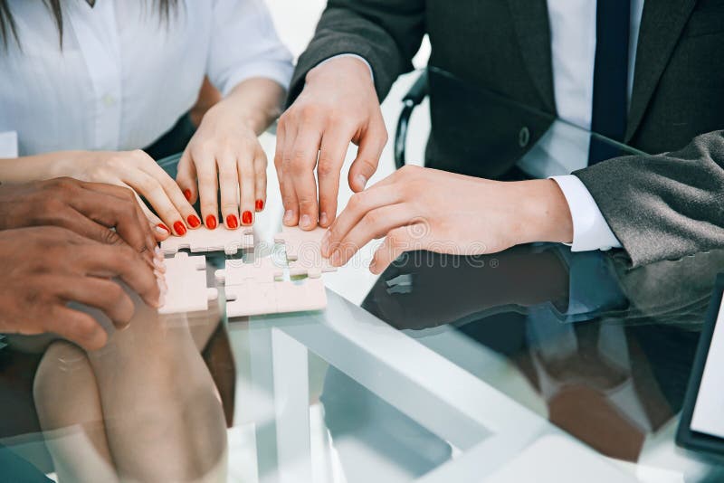 Closeup .business Team Assembling Puzzle Sitting Behind a Desk Stock ... Closeup .business Team Assembling Puzzle Sitting Behind a Desk Stock ...