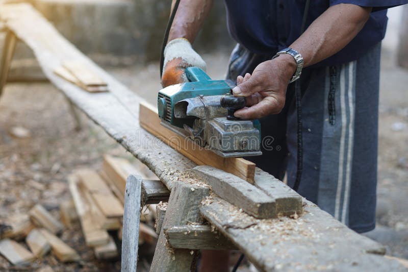 Closeup Carpenter Using Electric Planer with Wooden Plank in Carpentry ...
